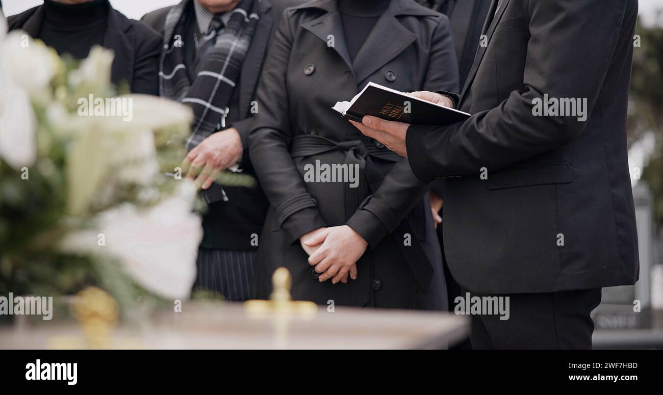 Bible, hands and family at funeral, cemetery or burial ceremony ...
