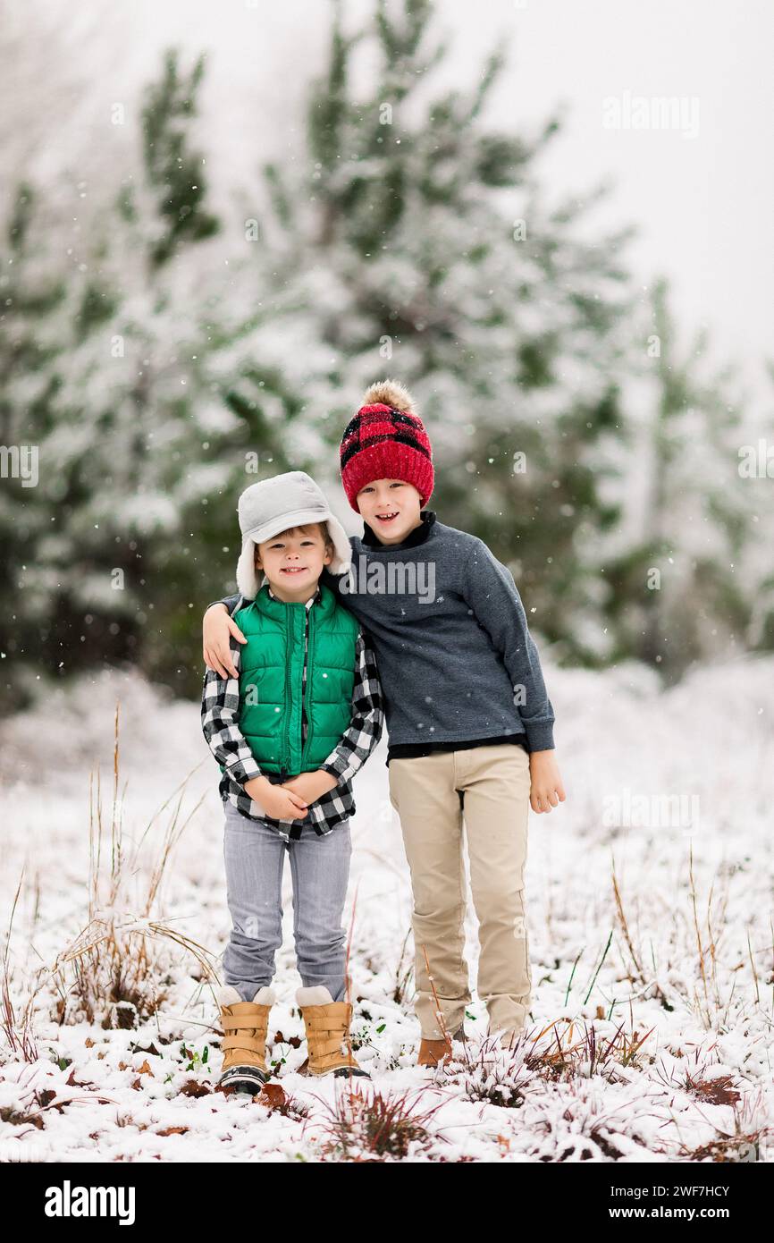Two little boys enjoying the snow wearing knit hats Stock Photo - Alamy