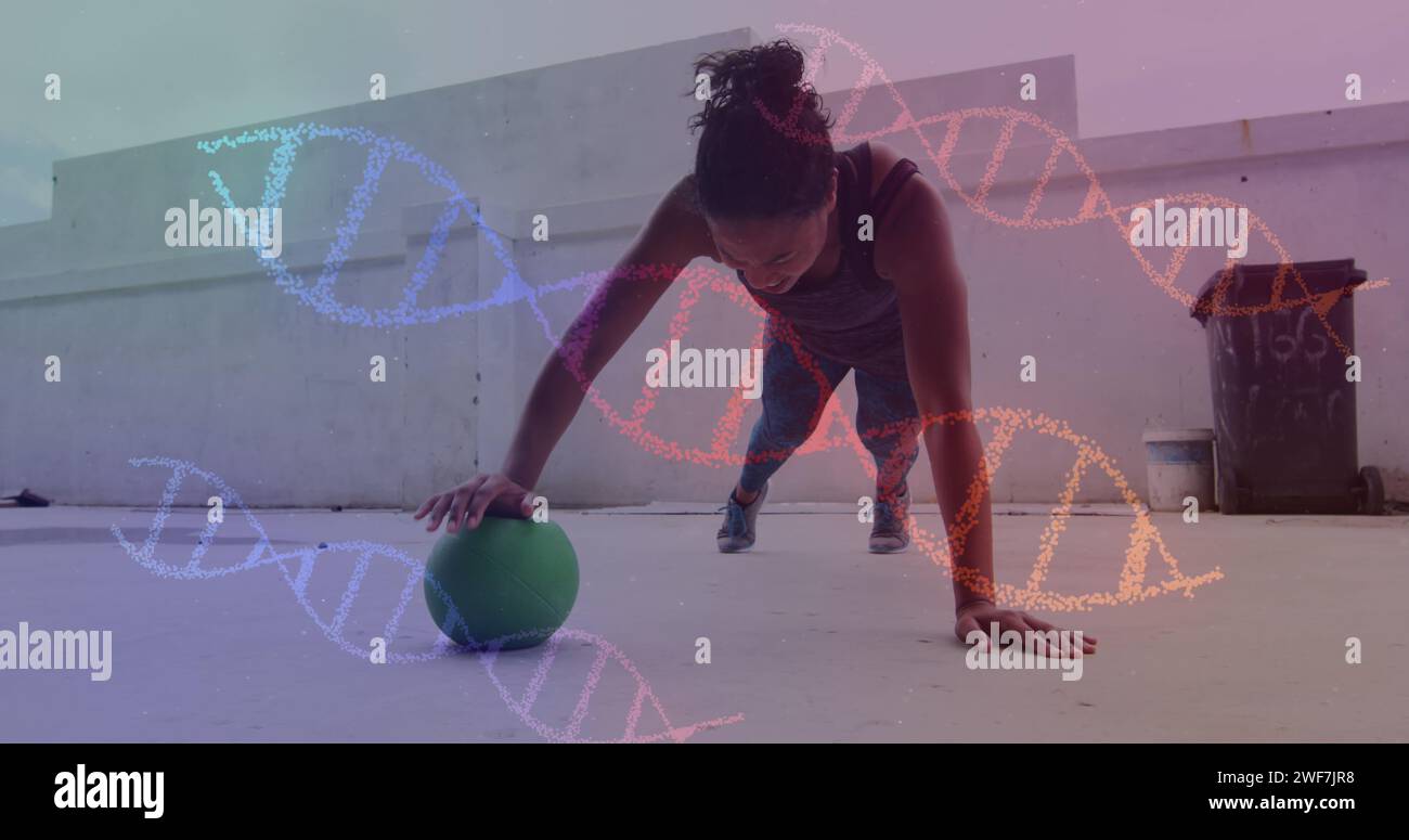 Image of dna strands spinning over woman doing press ups, exercising ...