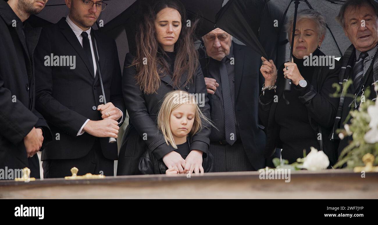 Loss, grief and people at funeral with umbrella, flowers and coffin ...