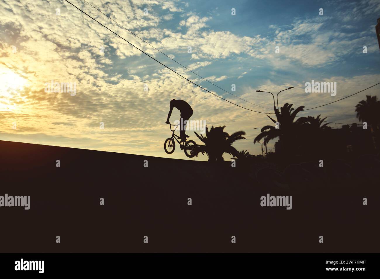 Silhouette unrecognizable Young man doing ramp jump stunt on bmx ...