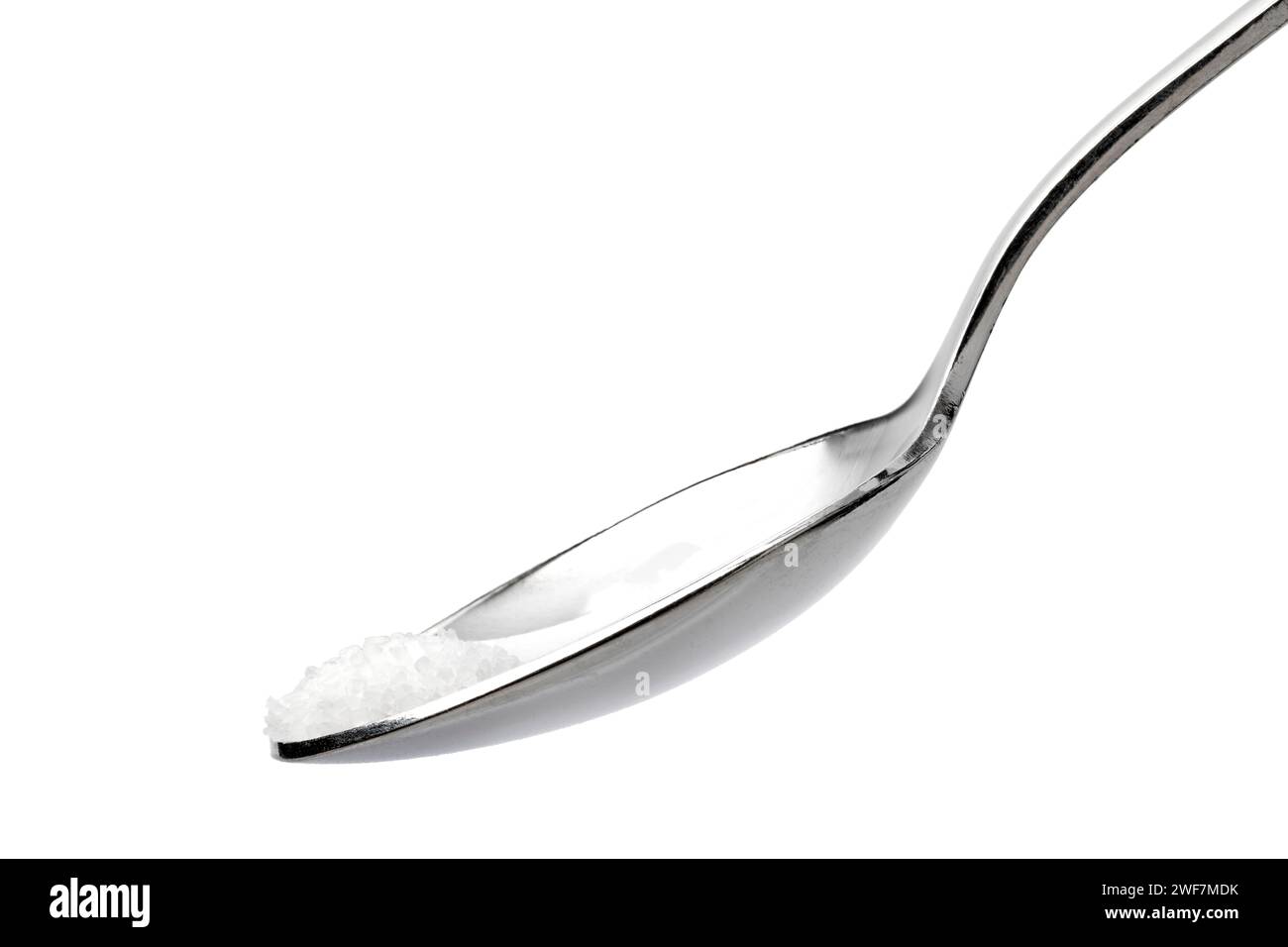 Metal spoon with a pinch of salt close up on white background Stock ...