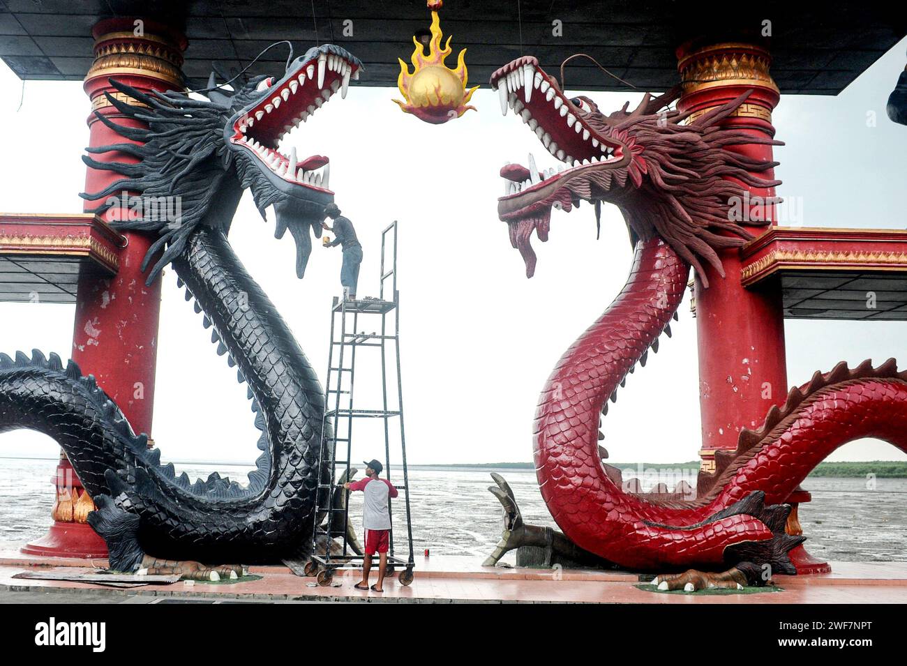Surabaya, Indonesia. 29th Jan, 2024. Workers repaint dragon statues in ...