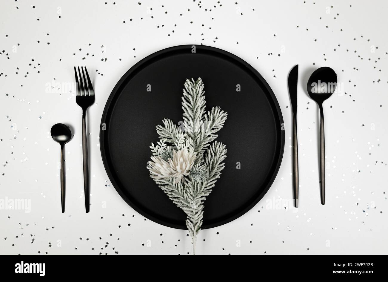 Christmas composition, black plate and cutlery, fir tree branch, silver ...