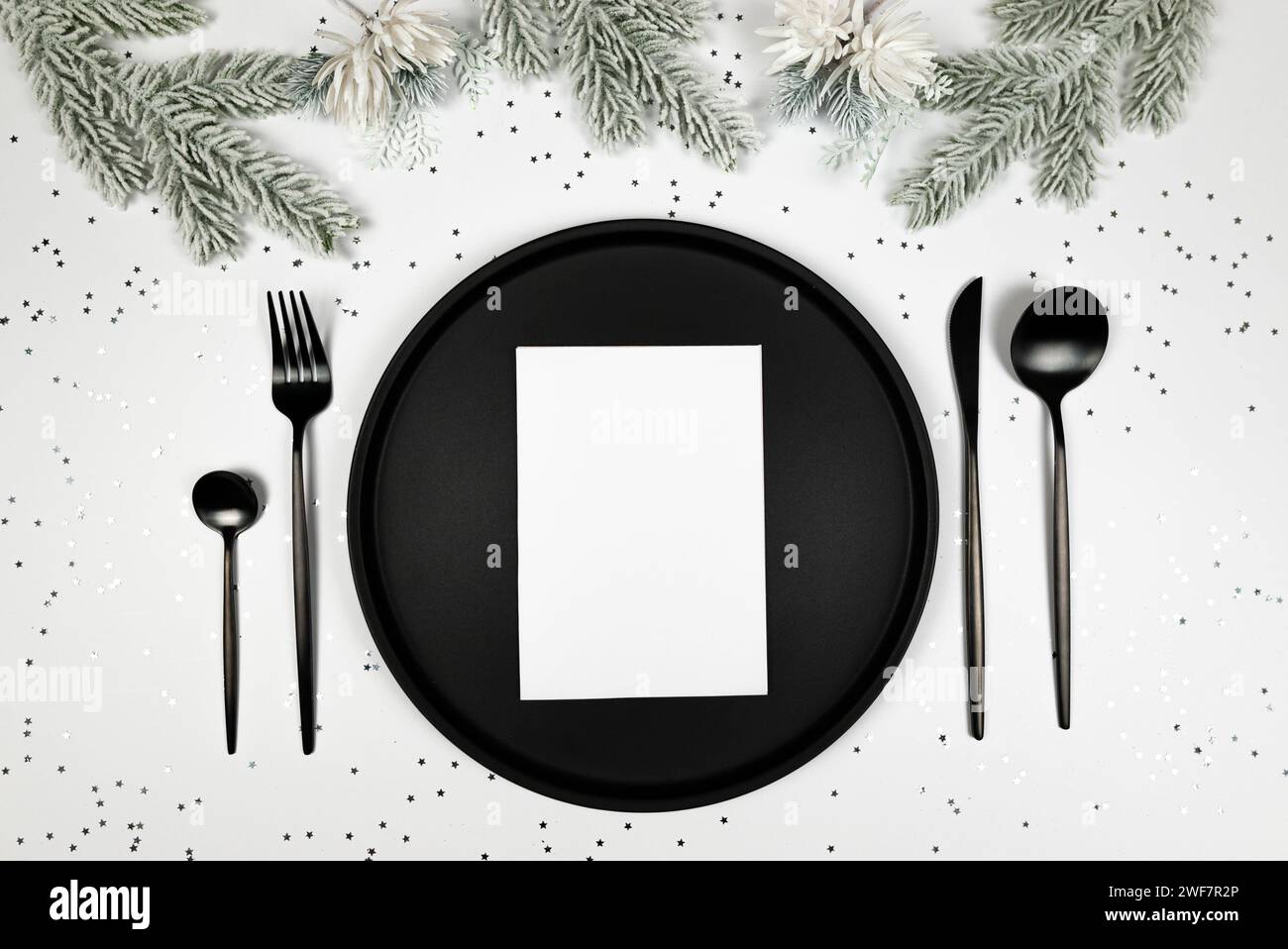 Christmas composition, black plate and cutlery, white card, fir tree ...