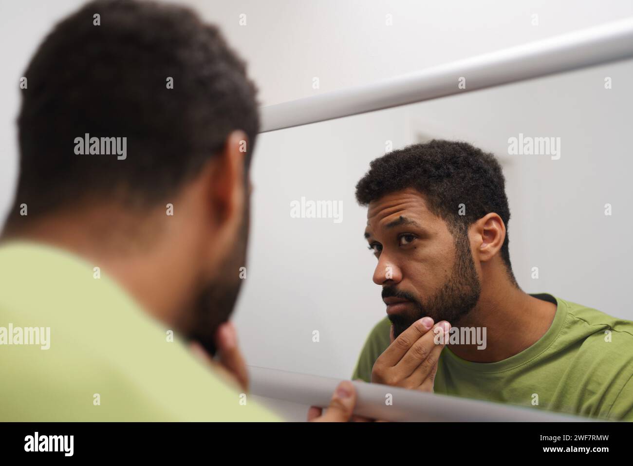 Man looking at himself in the mirror, feeling anxious and depressed in ...
