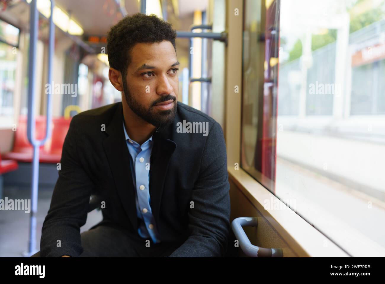 Portrait of handsome man traveling by bus, heading home after long work ...