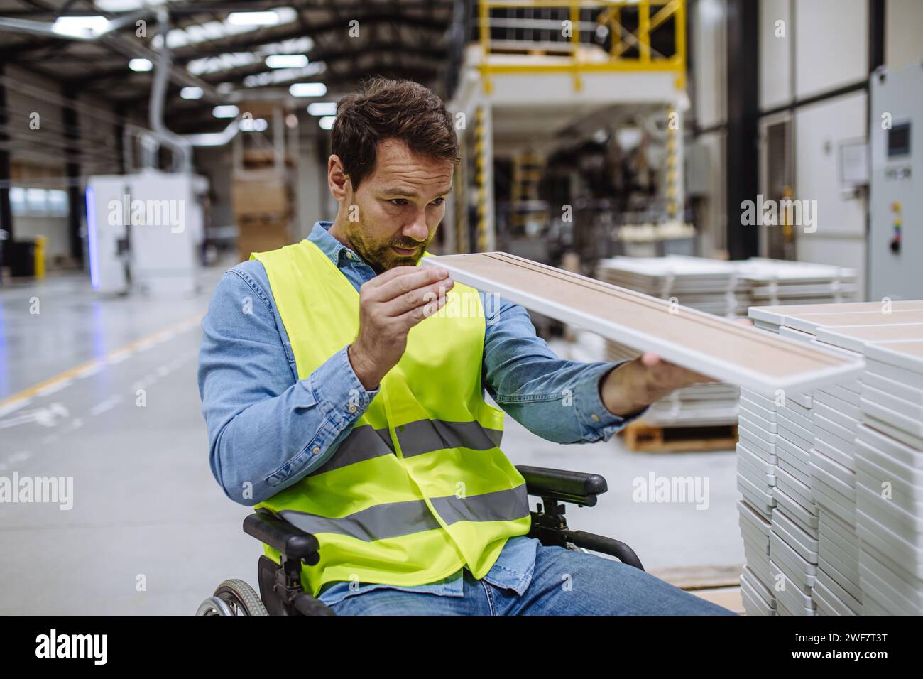 Portrait of man in wheelchair working in modern industrial factory ...