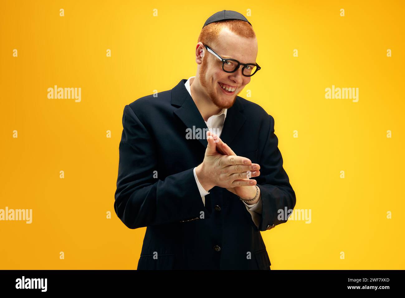 Portrait of happy young redhead Jewish man in glasses and yarmulke ...