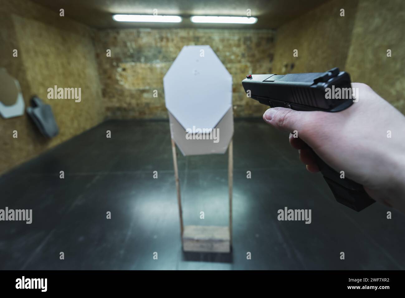 Tactical pistol shooting at a paper target at a shooting range. High ...