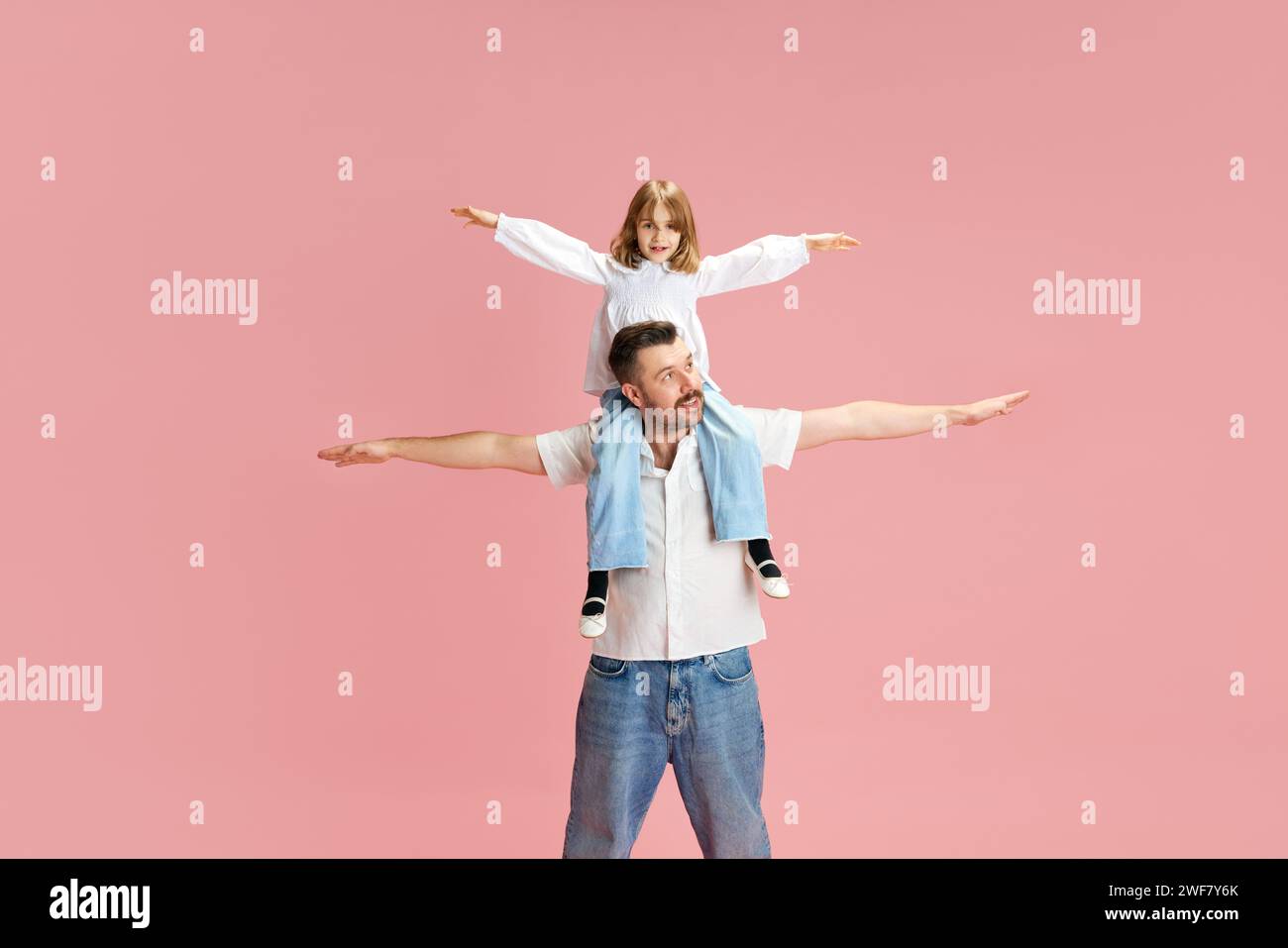 Father and daughter with arms outstretched, play airplanes pretending ...