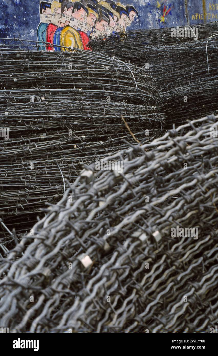 Barbed wire in front of a painting on the wall that separates the ...