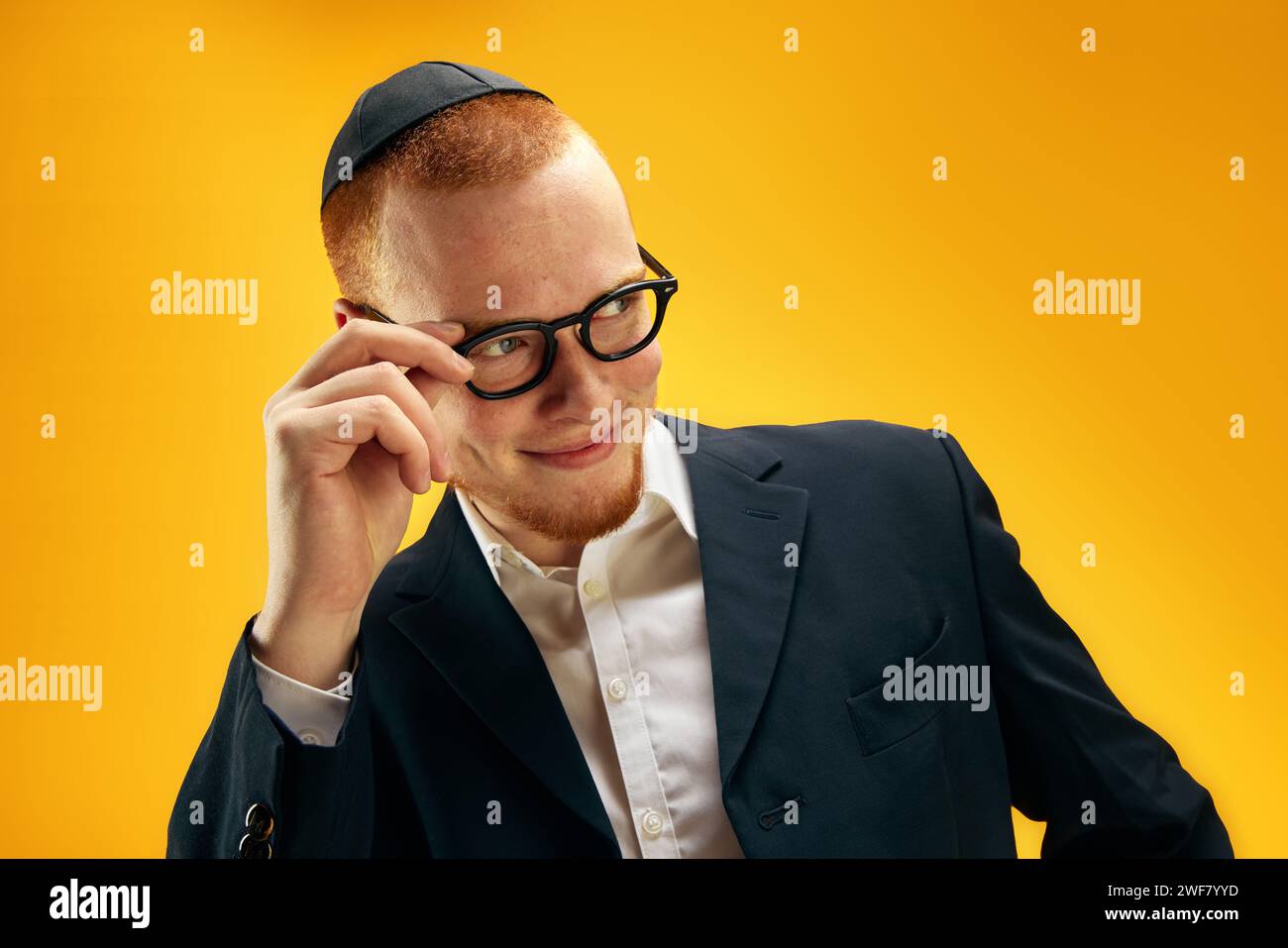 Portrait of young redhead Jewish man in yarmulke, glasses and suit ...