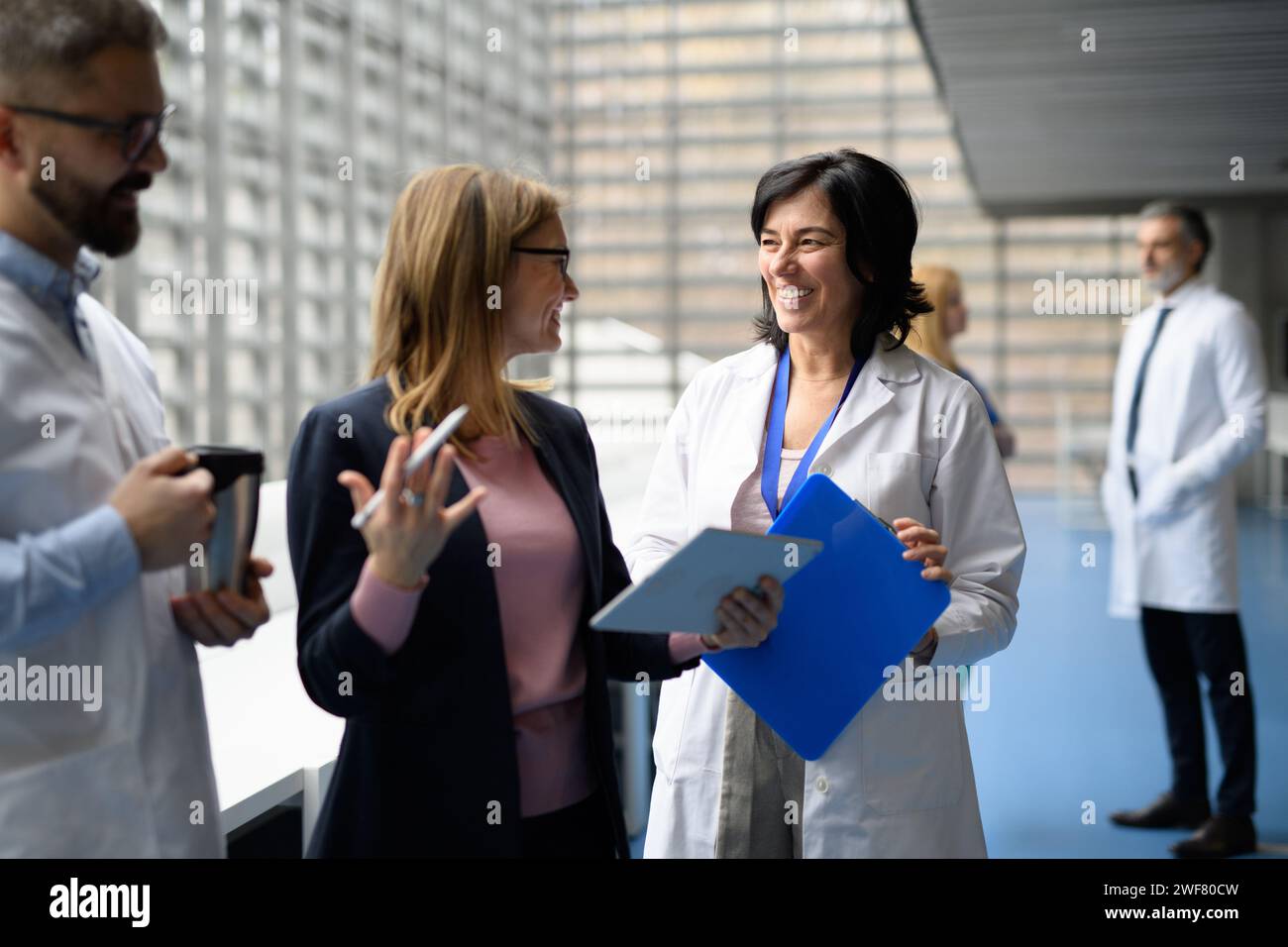 Doctors talking to pharmaceutical sales representative, presenting new ...