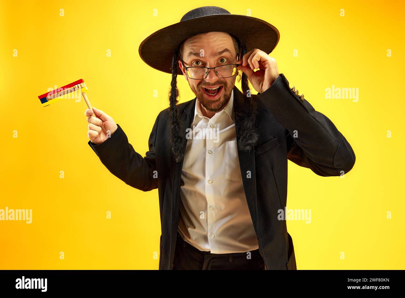 Emotional, excited young Jewish man in hat, with sidelocks, in glasses ...
