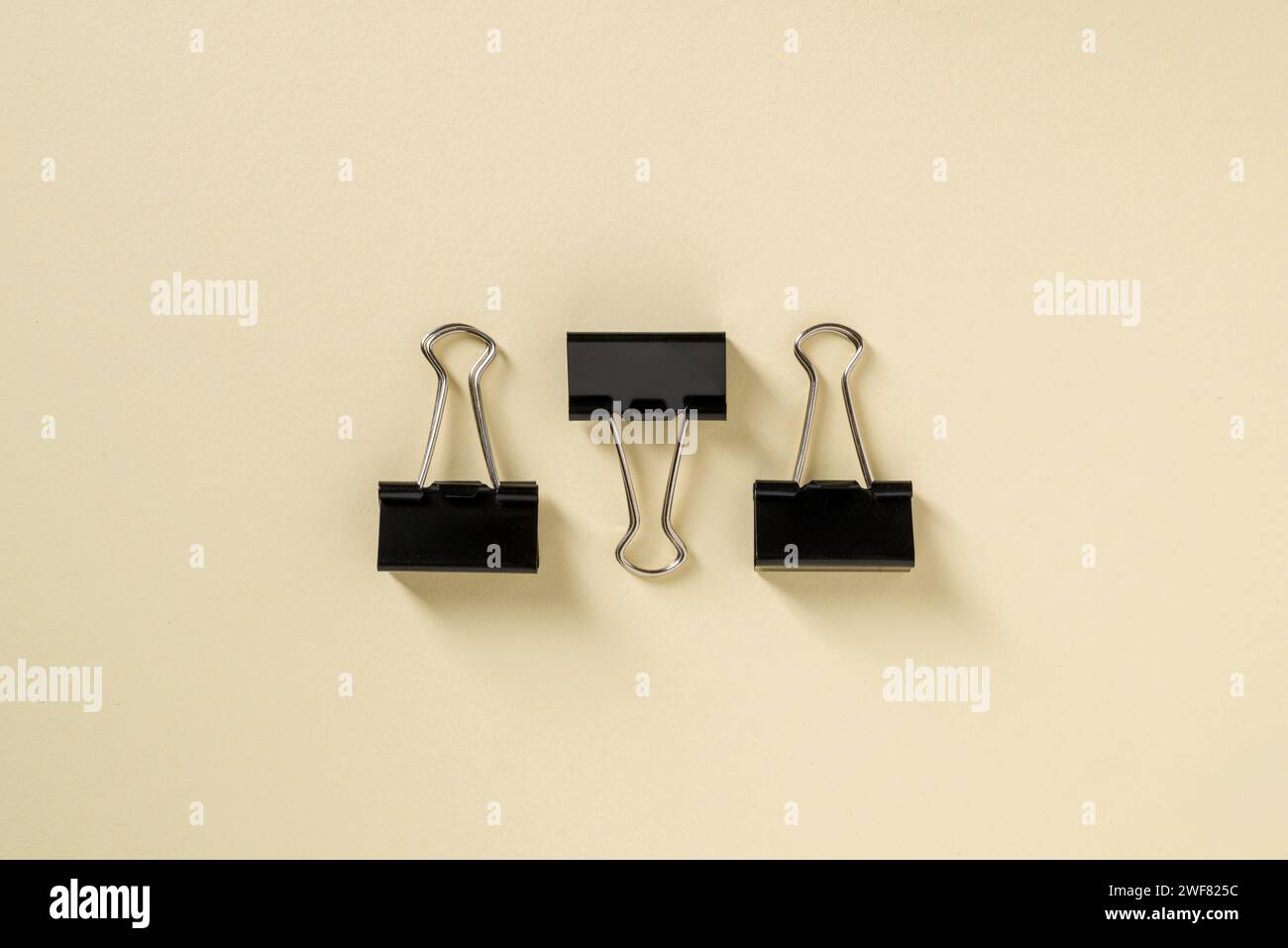 Black binder paper clip on yellow background Stock Photo - Alamy