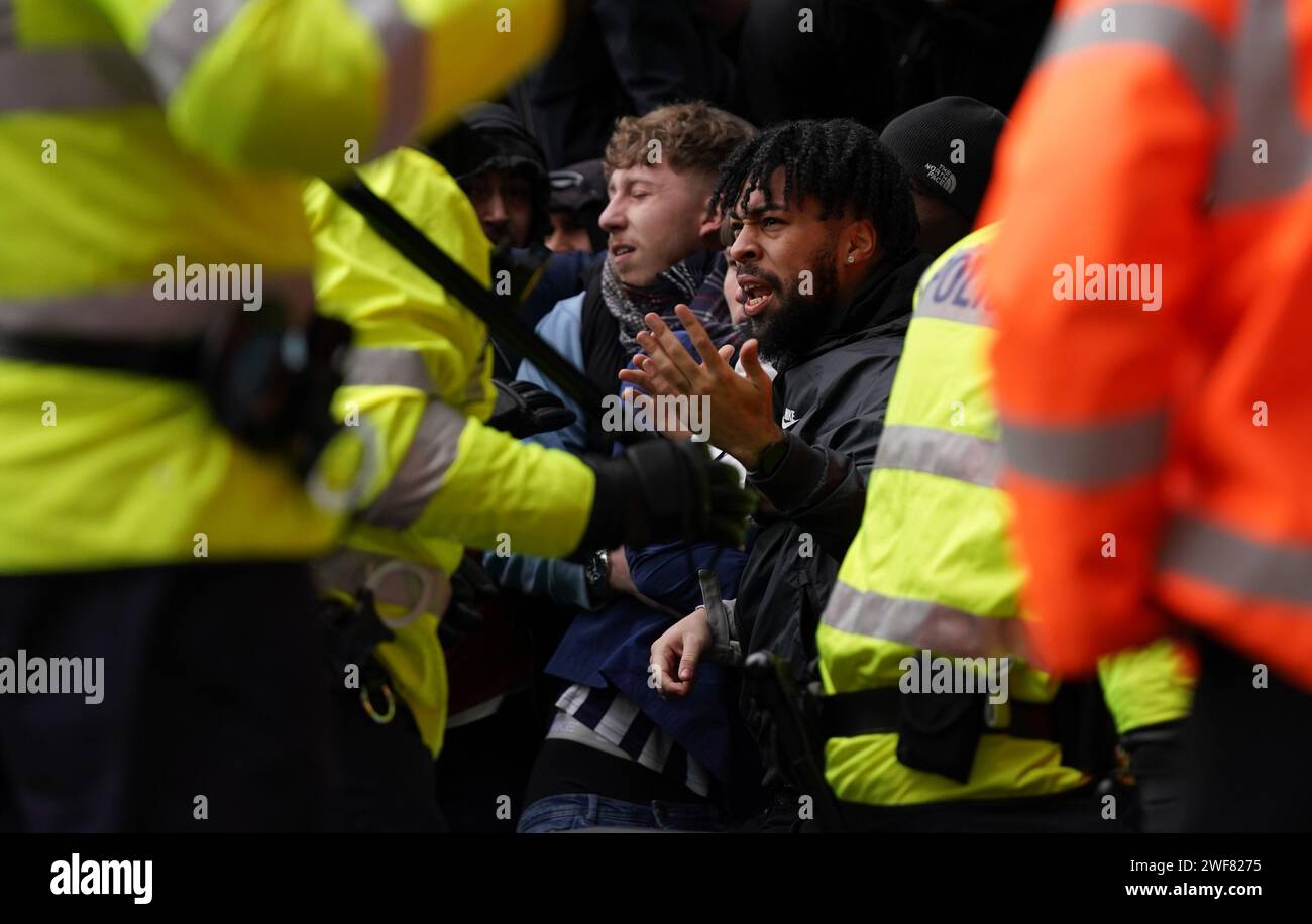 Fans invading the pitch clash with police officers during the Emirates ...