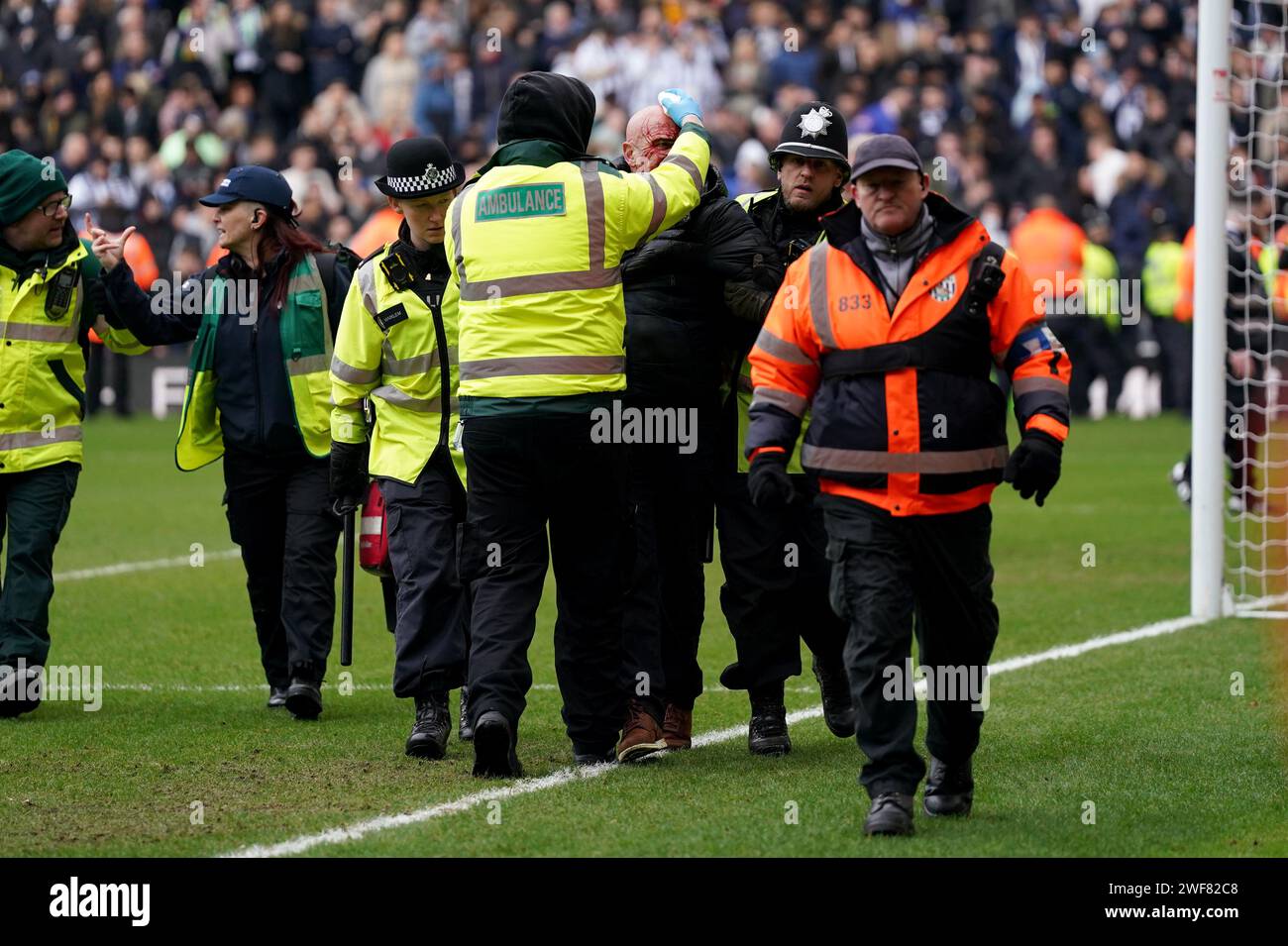 EDITORS NOTE - BLOOD Police officers remove a fan who received a cut to ...
