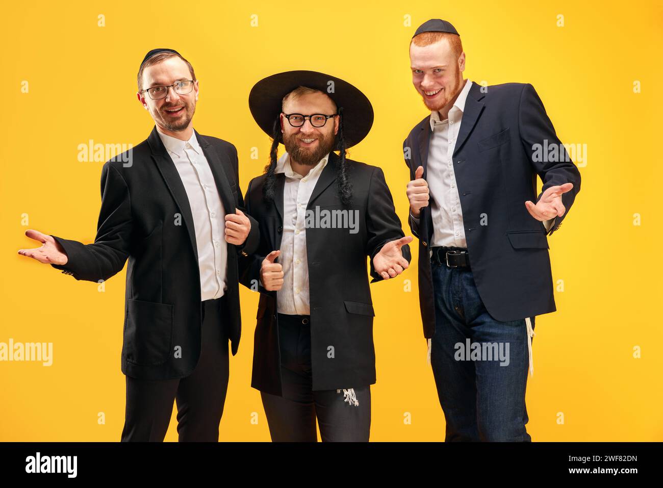 Three Jewish men, friends in traditional Jewish attributes smiling ...