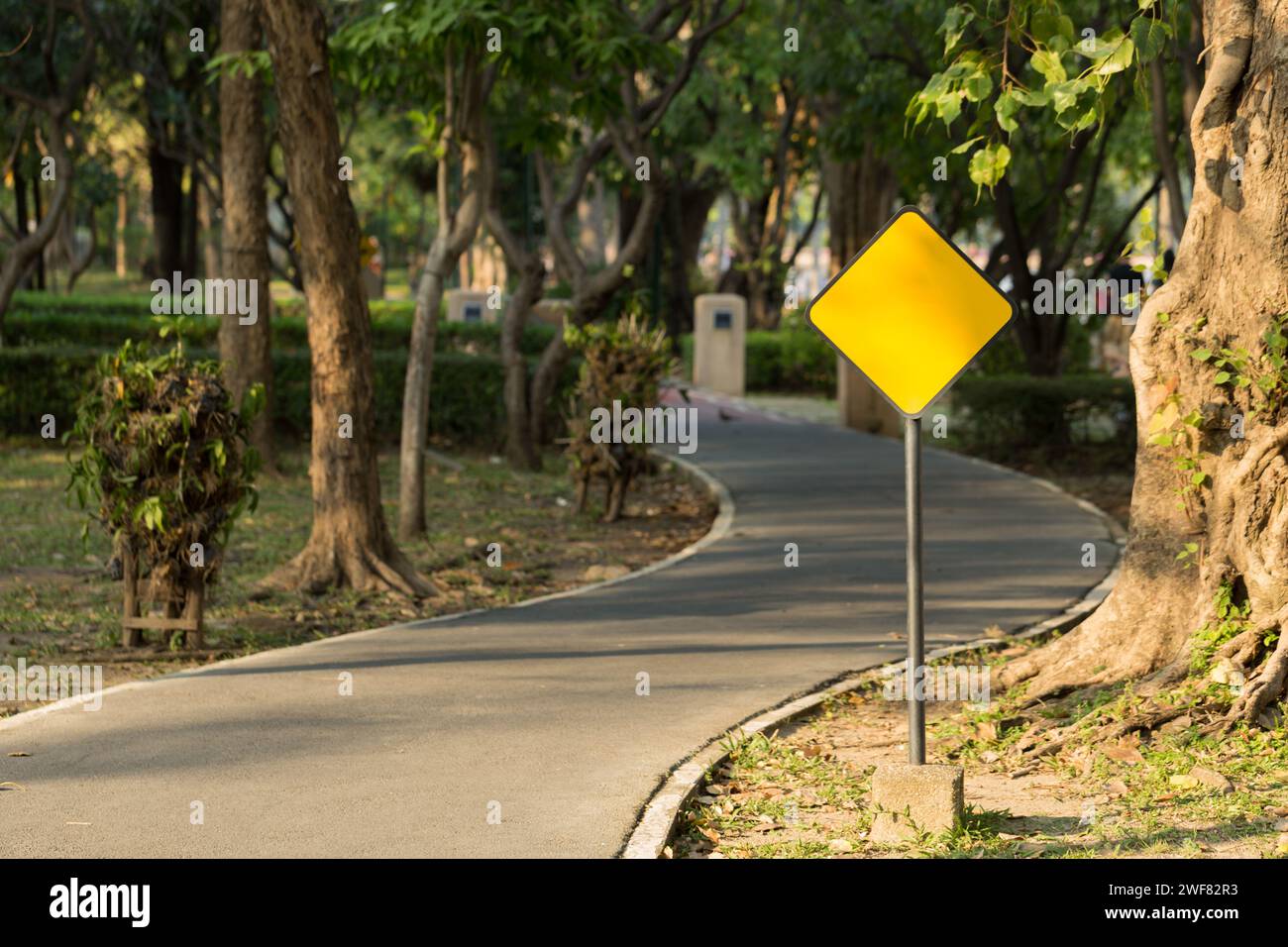 Empty yellow metal sign by the roadside for running in the public park ...