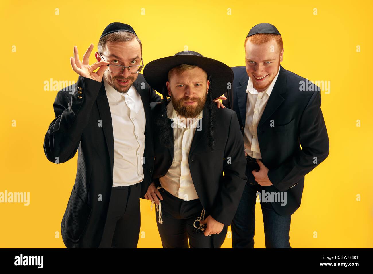 Three Jewish men, friends in traditional Jewish attributes smiling ...