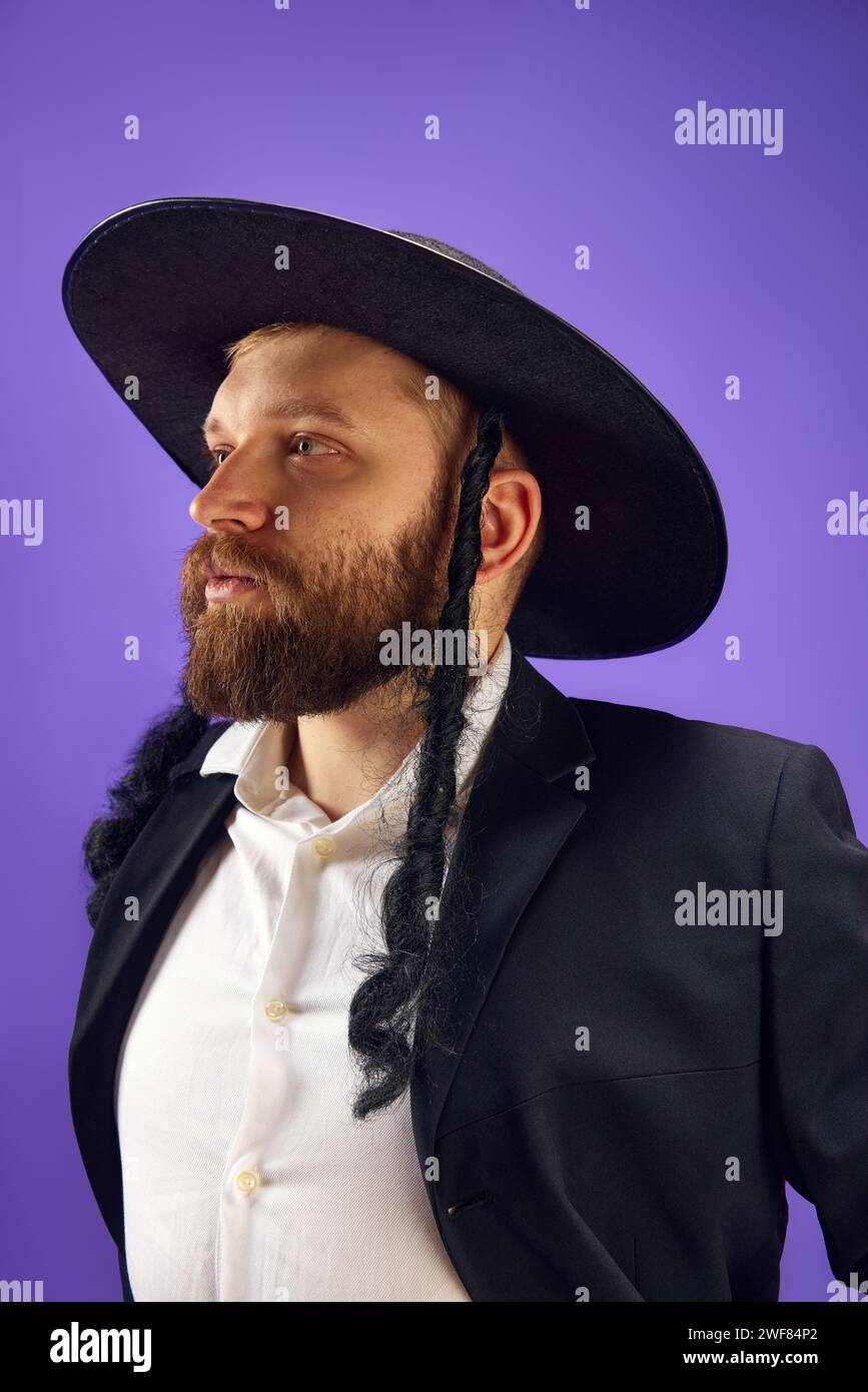Portrait of bearded young Jewish man in hat, with sidelocks posing ...