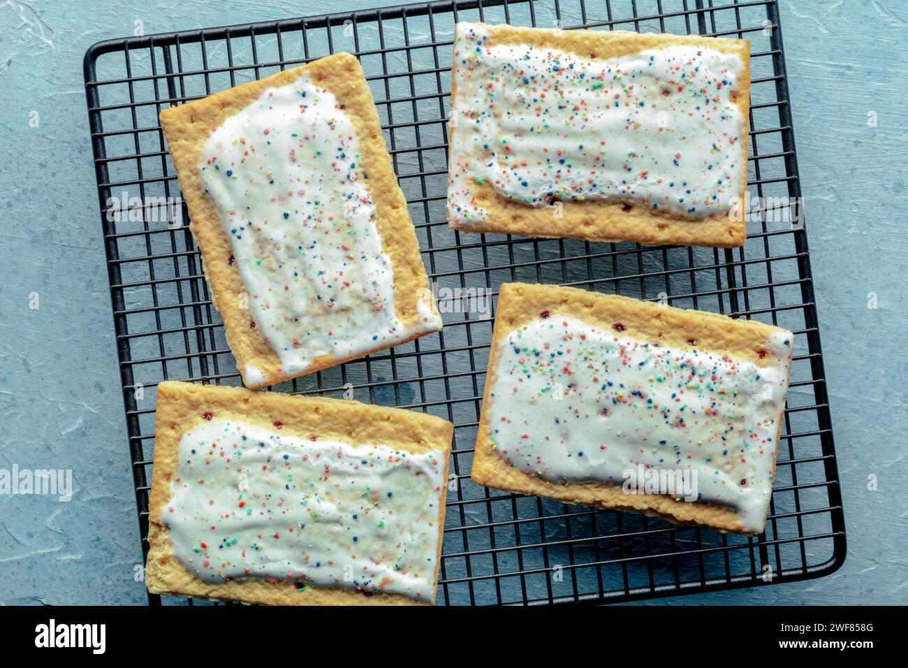 Pop tarts on a baking rack. Poptart toaster pastry with icing on a blue ...