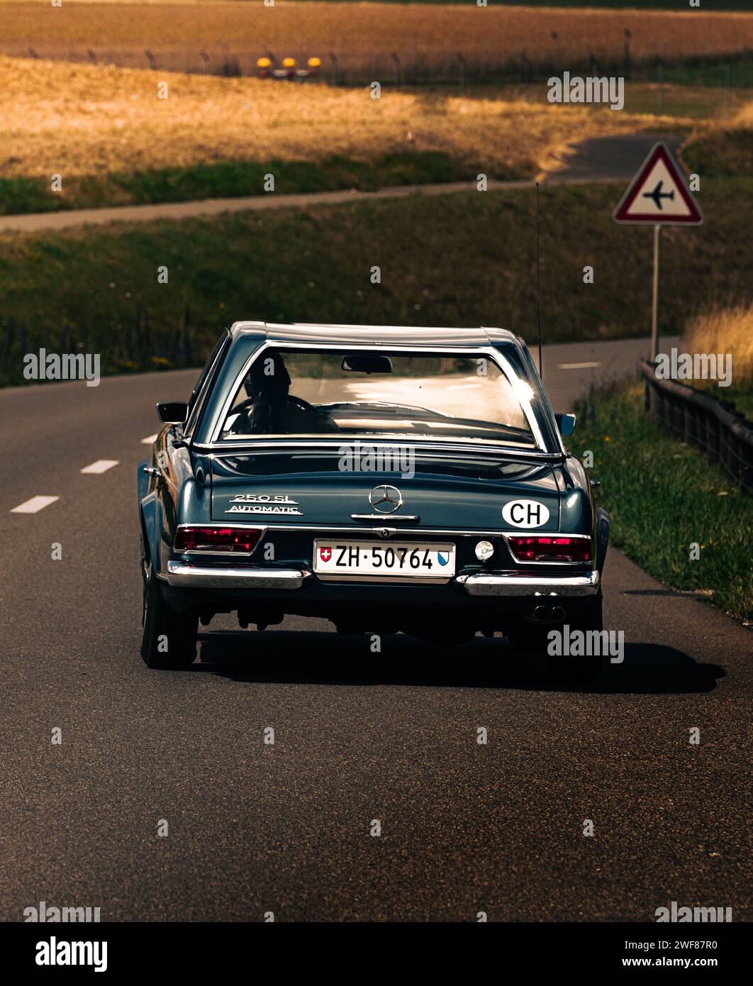 Mercedes Benz 350 SL oldtimer driving at a road at Zurich Airport at a ...