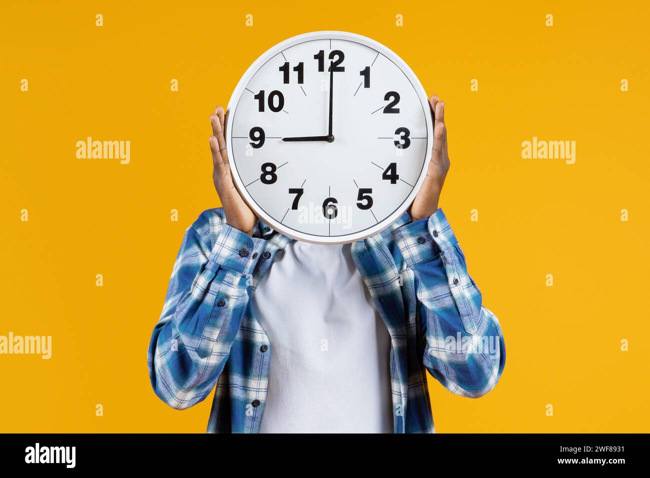 Unrecognizable black male holding large round clock in front of his ...