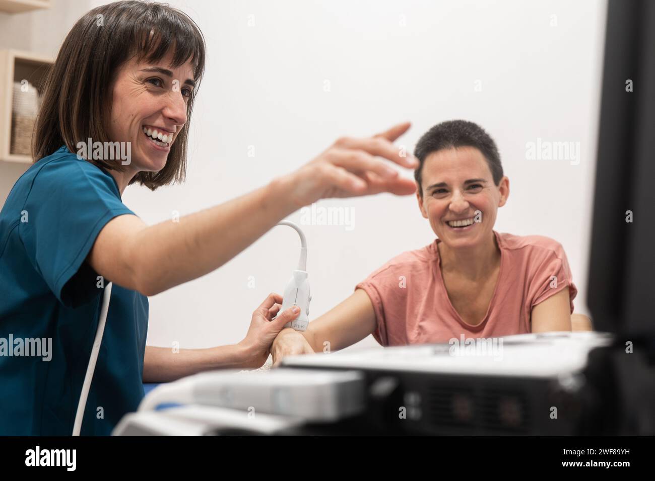 A female ultrasound technician shares a lighthearted moment with a ...