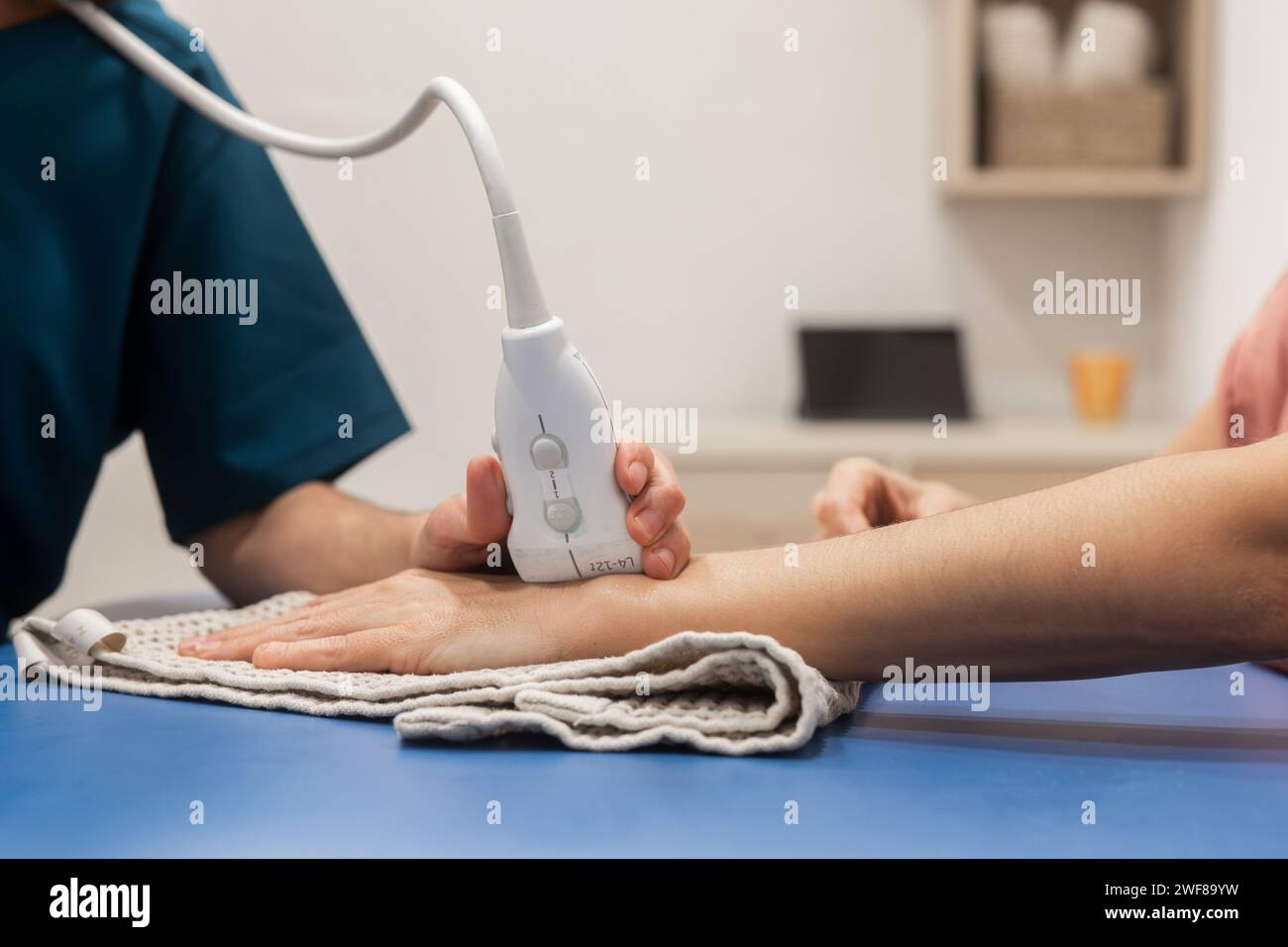 A healthcare professional is applying ultrasound therapy using a ...