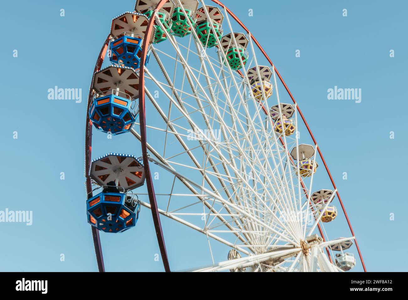 From below static Ferris wheel against a clear blue sky, showcasing its ...