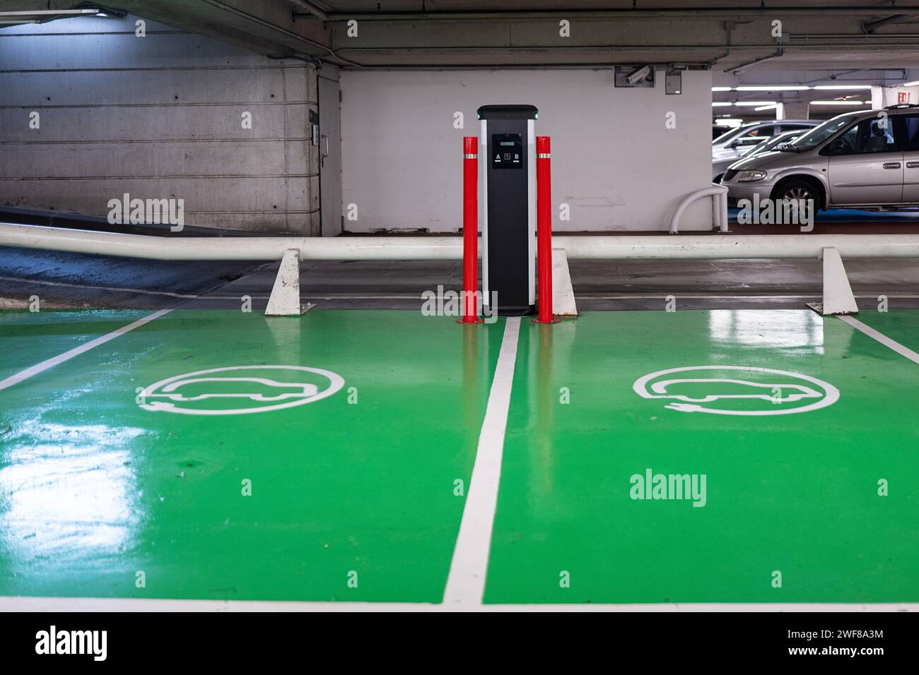 Close-up view of electric charging stations with vibrant green ground ...
