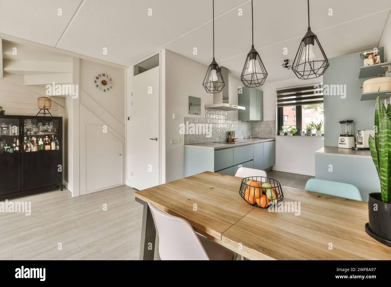 A contemporary kitchen featuring sleek cabinetry, hanging lights, and a ...