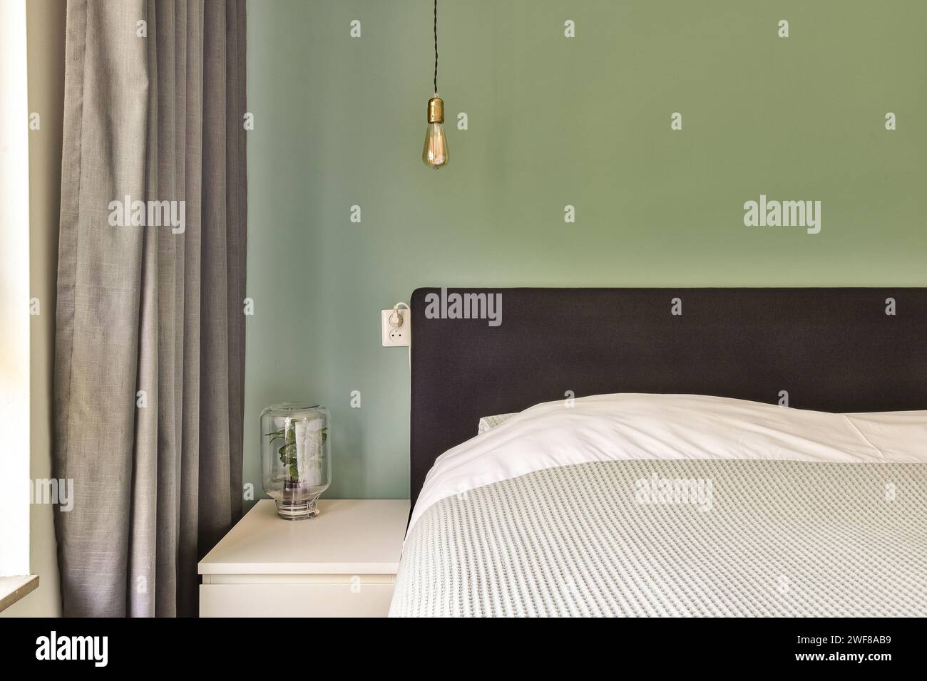 A cozy minimalist bedroom featuring a comfortable bed, modern hanging ...