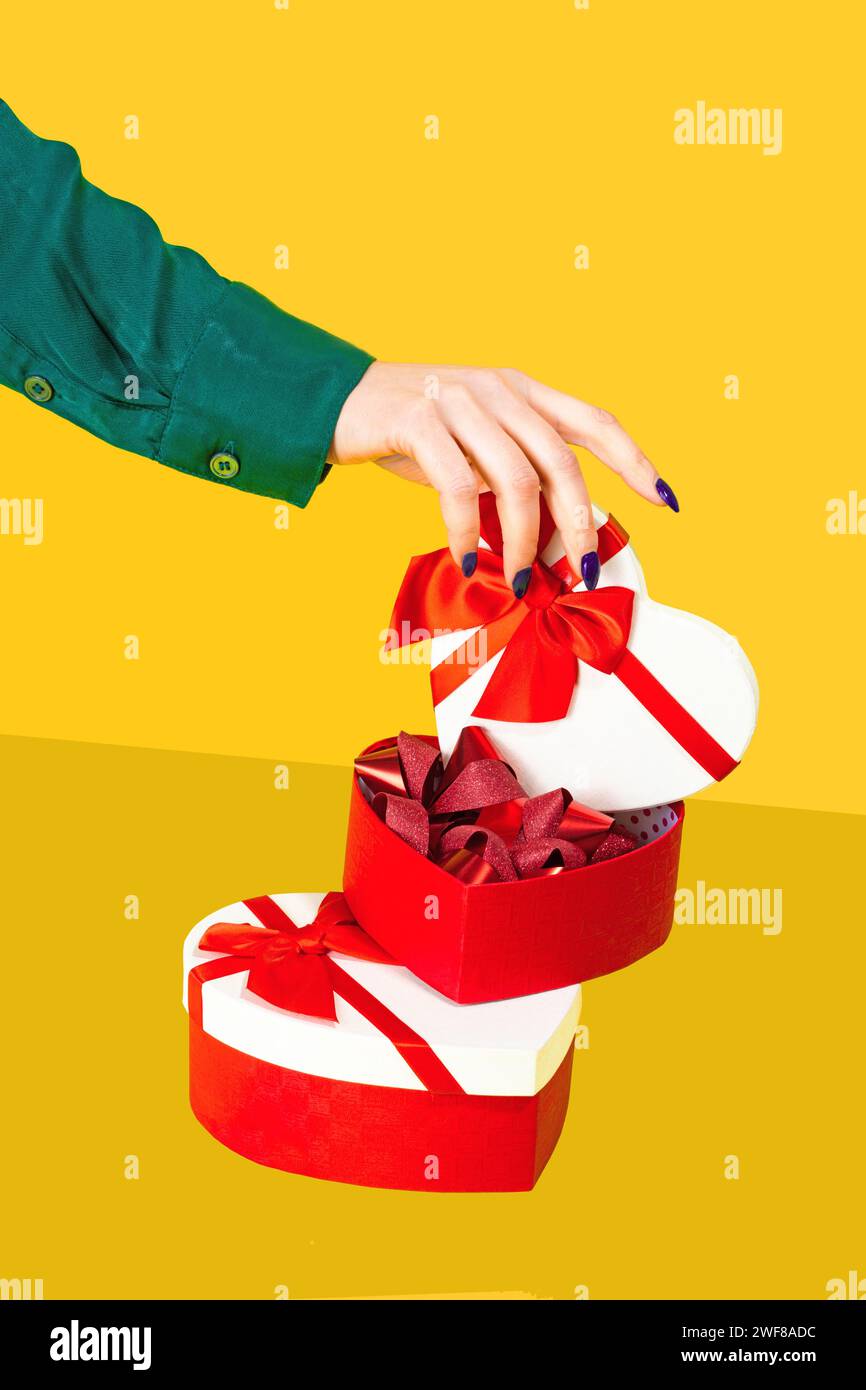 Anonymous hand lifting the lid off a heart shaped gift box revealing ...