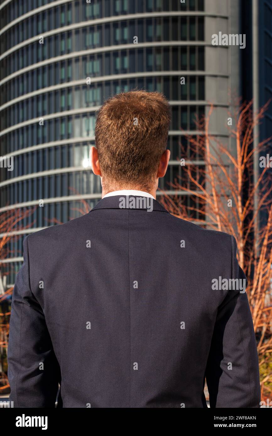 Back view of a well-dressed young man in a suit, standing and ...