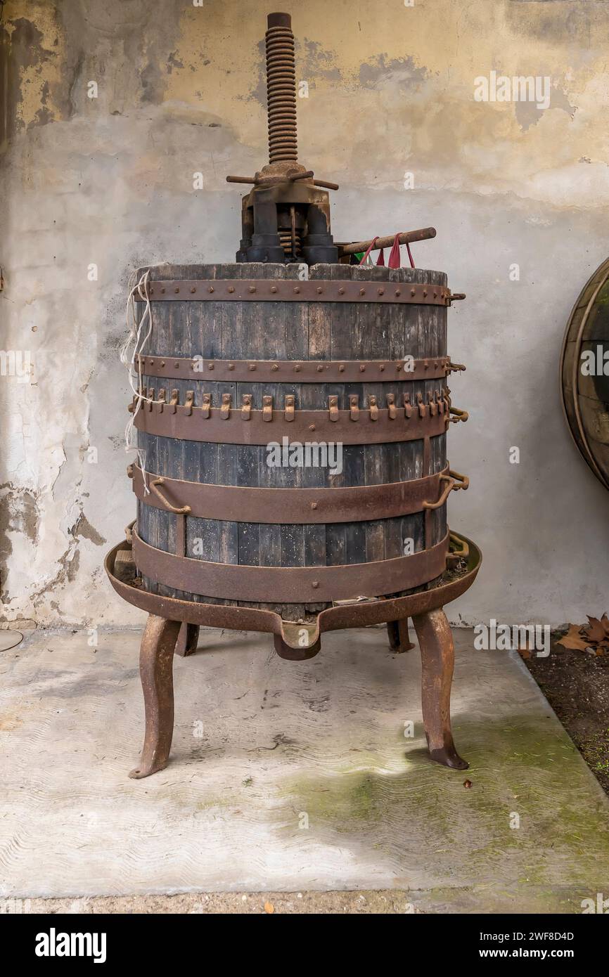An ancient wine press is displayed at the entrance of a Tuscan winery ...