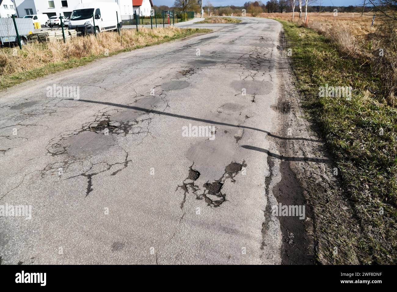 A damaged and hole-punched aflat road in the countryside Stock Photo ...
