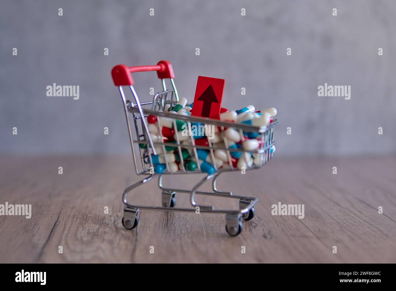 A shopping cart overflowing with colorful pills with a red arrow ...