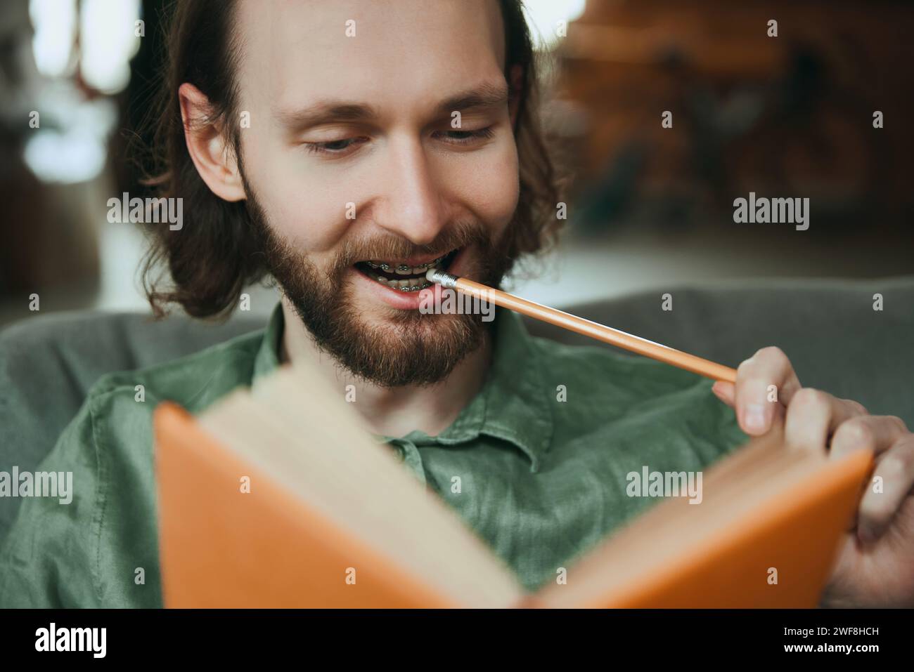 Excited young man, student sitting in public library and reading ...