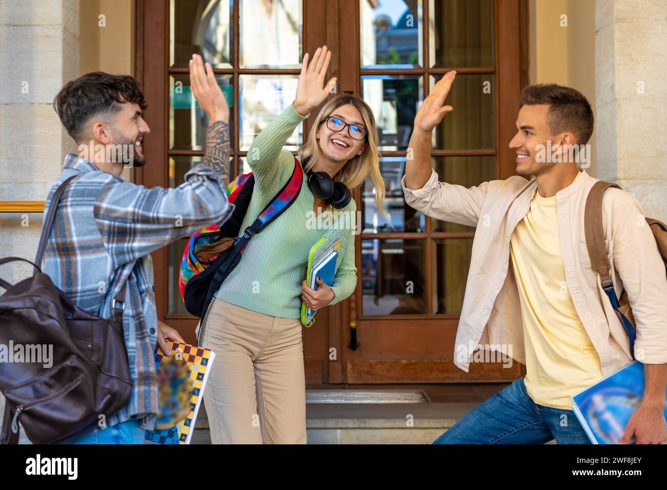 Young happy students having fun together outside university giving high ...