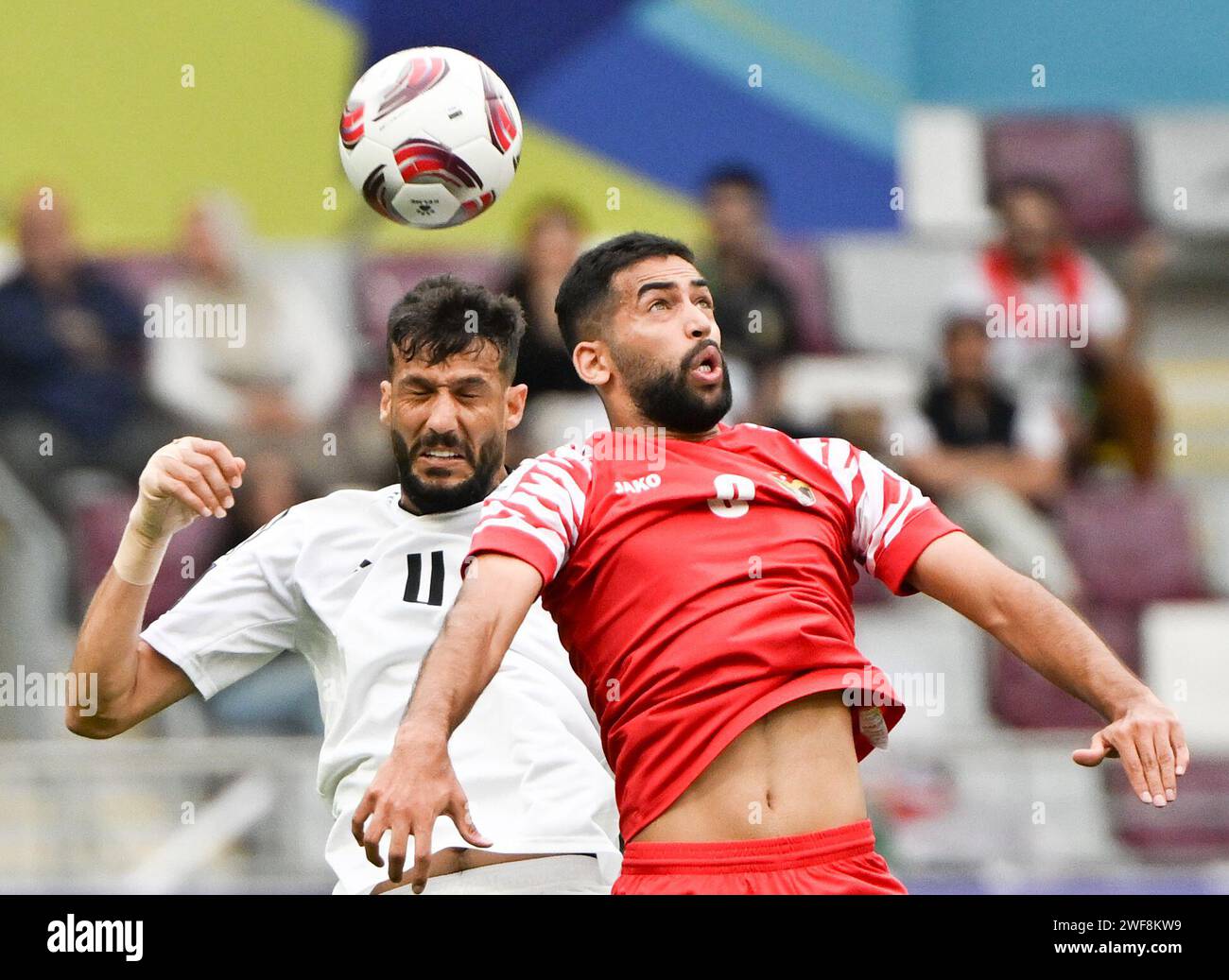Doha, Qatar. 29th Jan, 2024. Jordan's Ali Olwan (R) vies with Iraq's Zidane Aamar Iqbal during ...