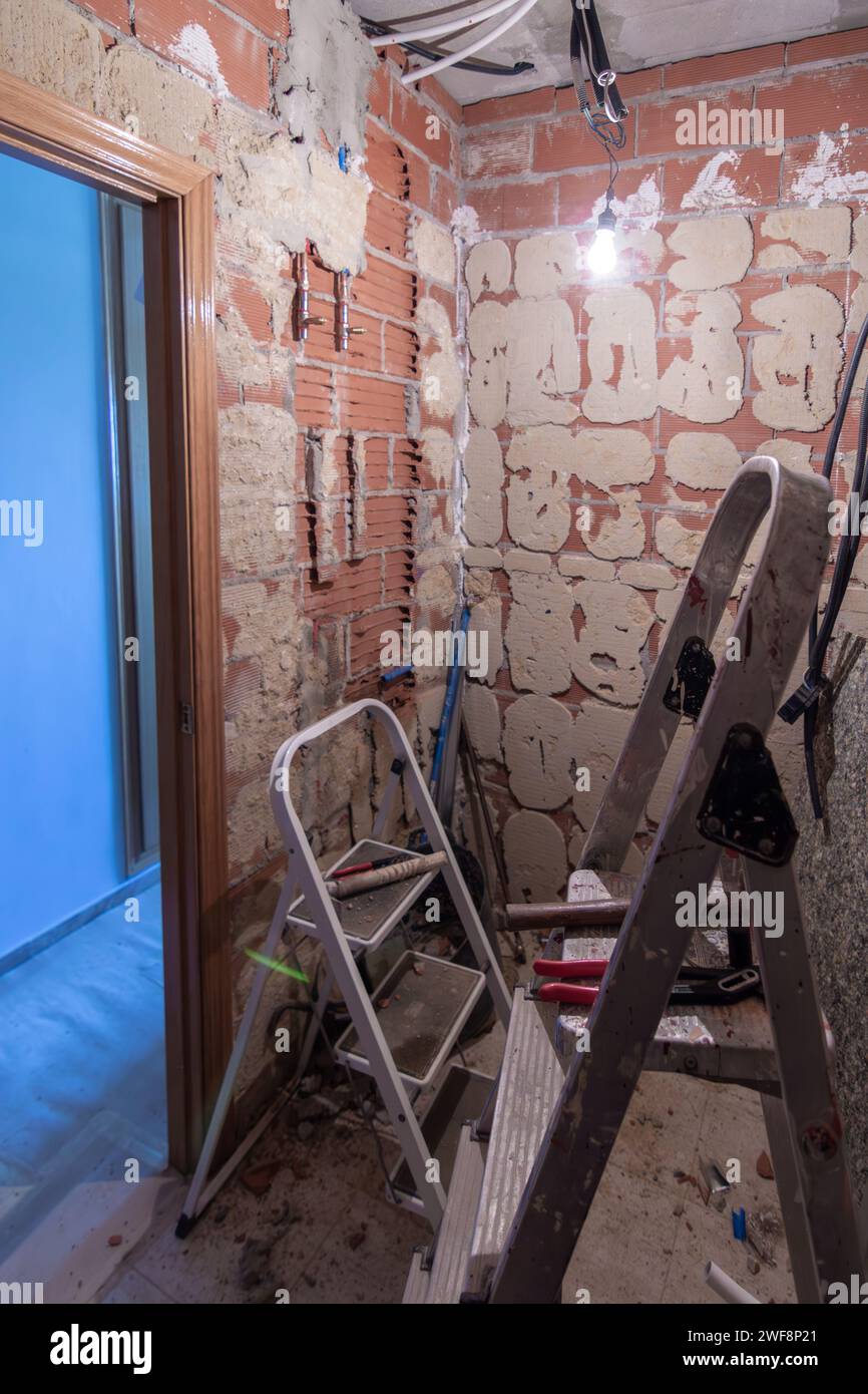 A room under renovation with chipped walls, debris on the floor ...