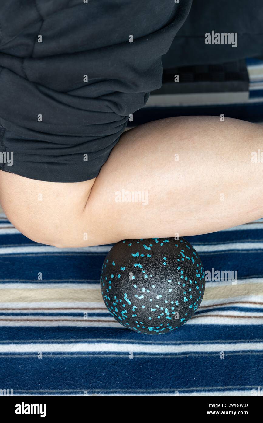 man using peanut-shaped massage balls to relax his anterior tibialis at ...
