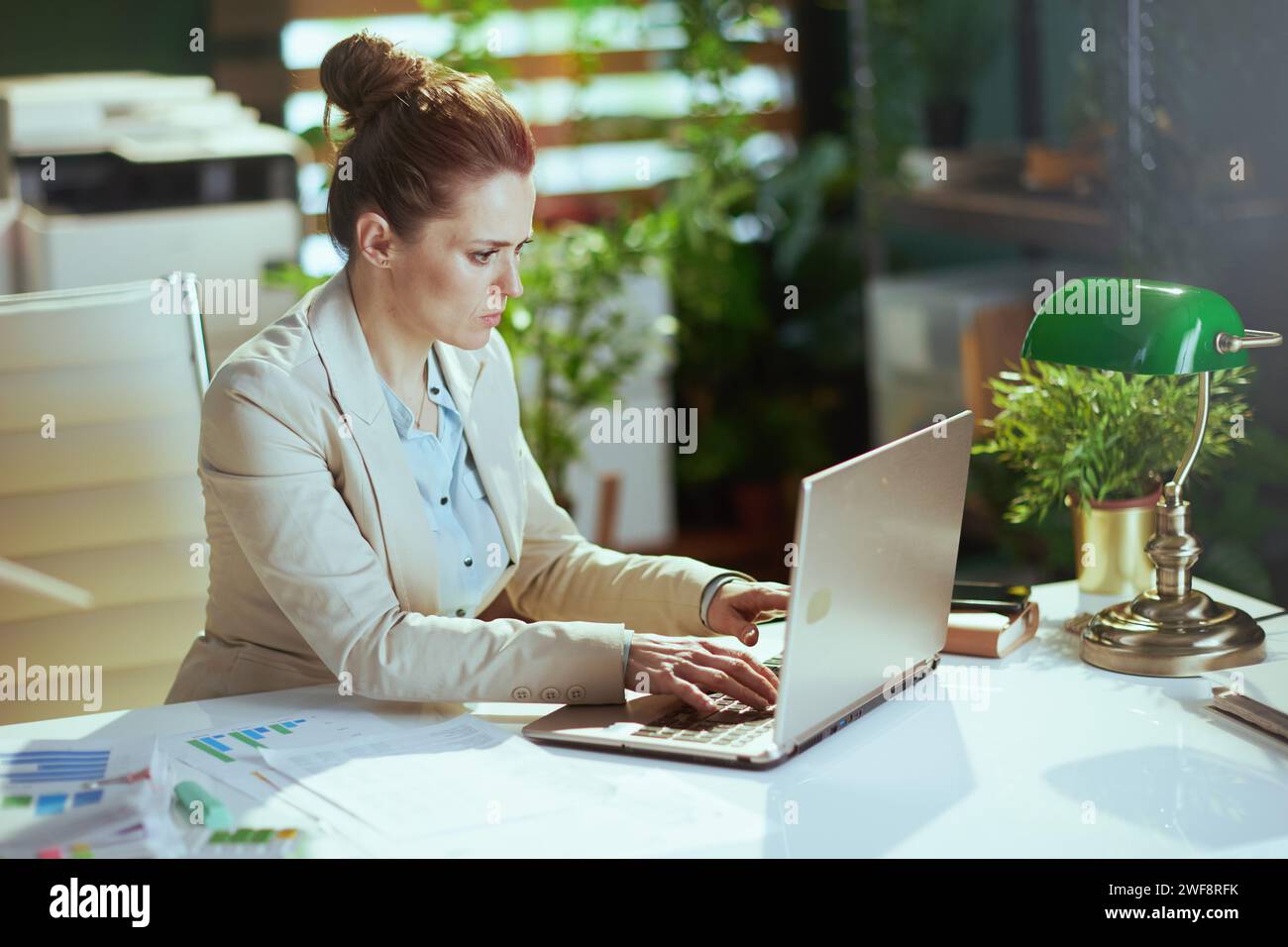 modern 40 years old woman employee in a light business suit in modern ...