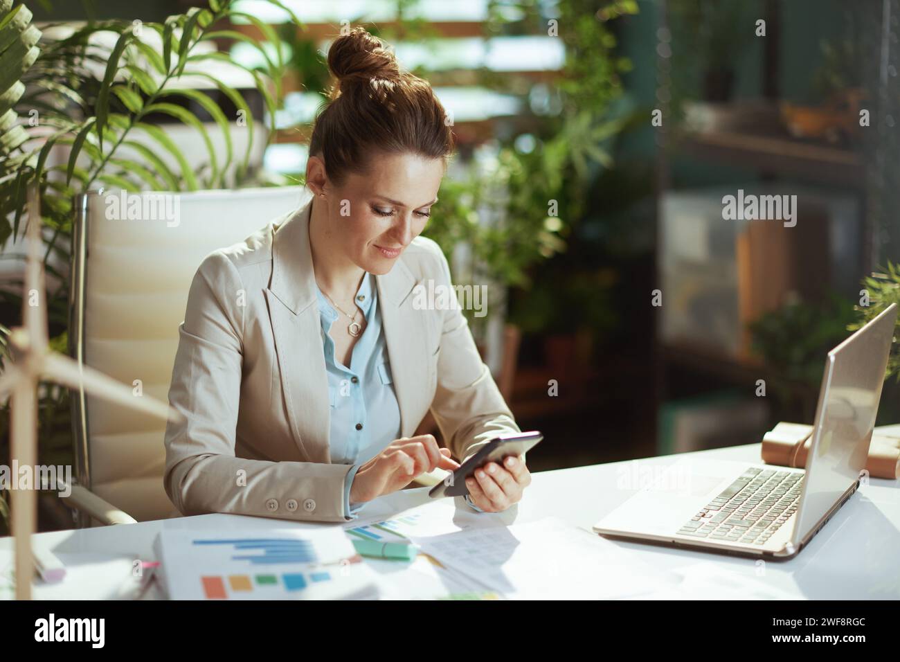 modern bookkeeper woman in a light business suit in modern green office ...