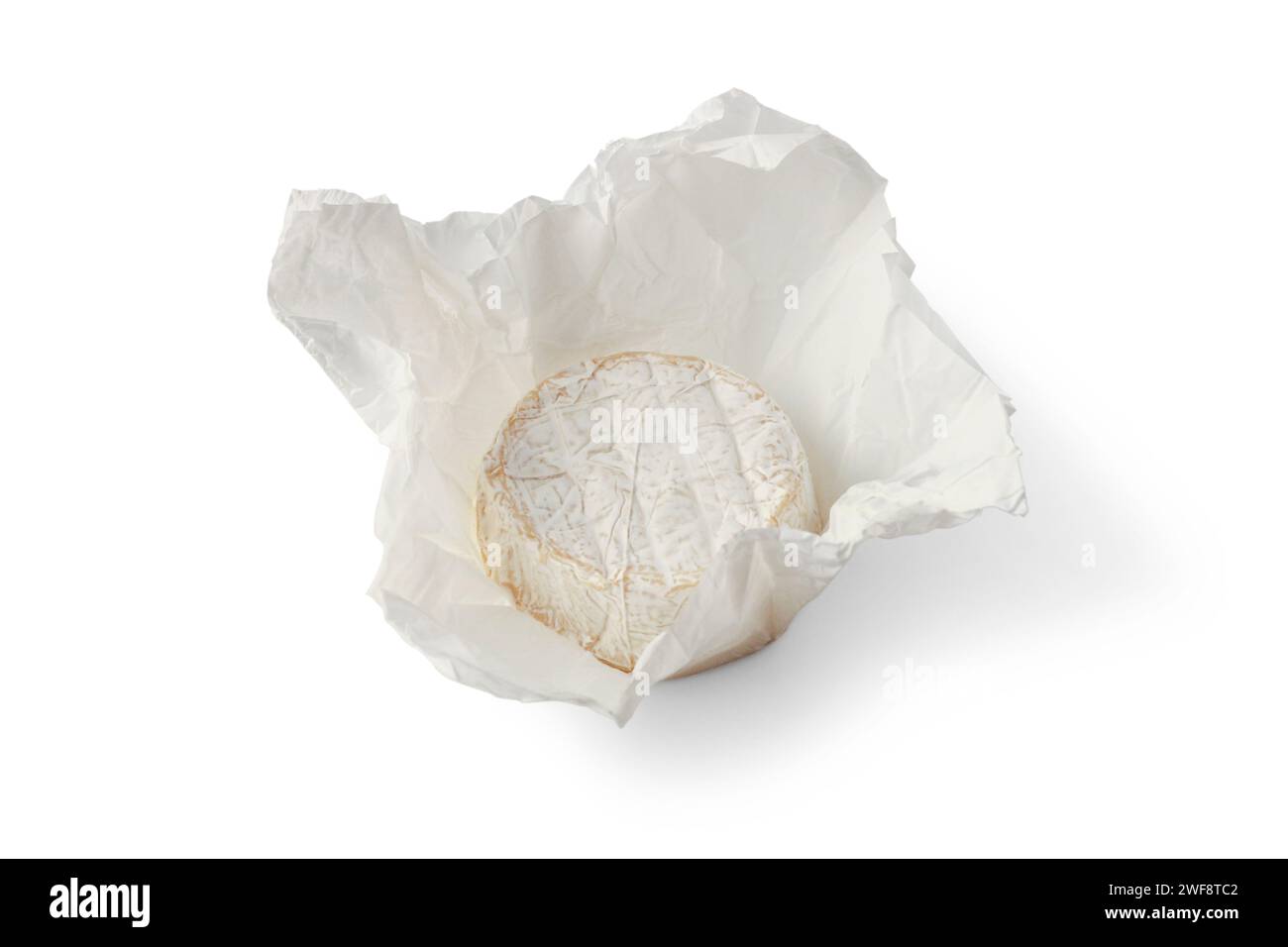 A head of camembert cheese in an unwrapped paper package isolated on a ...