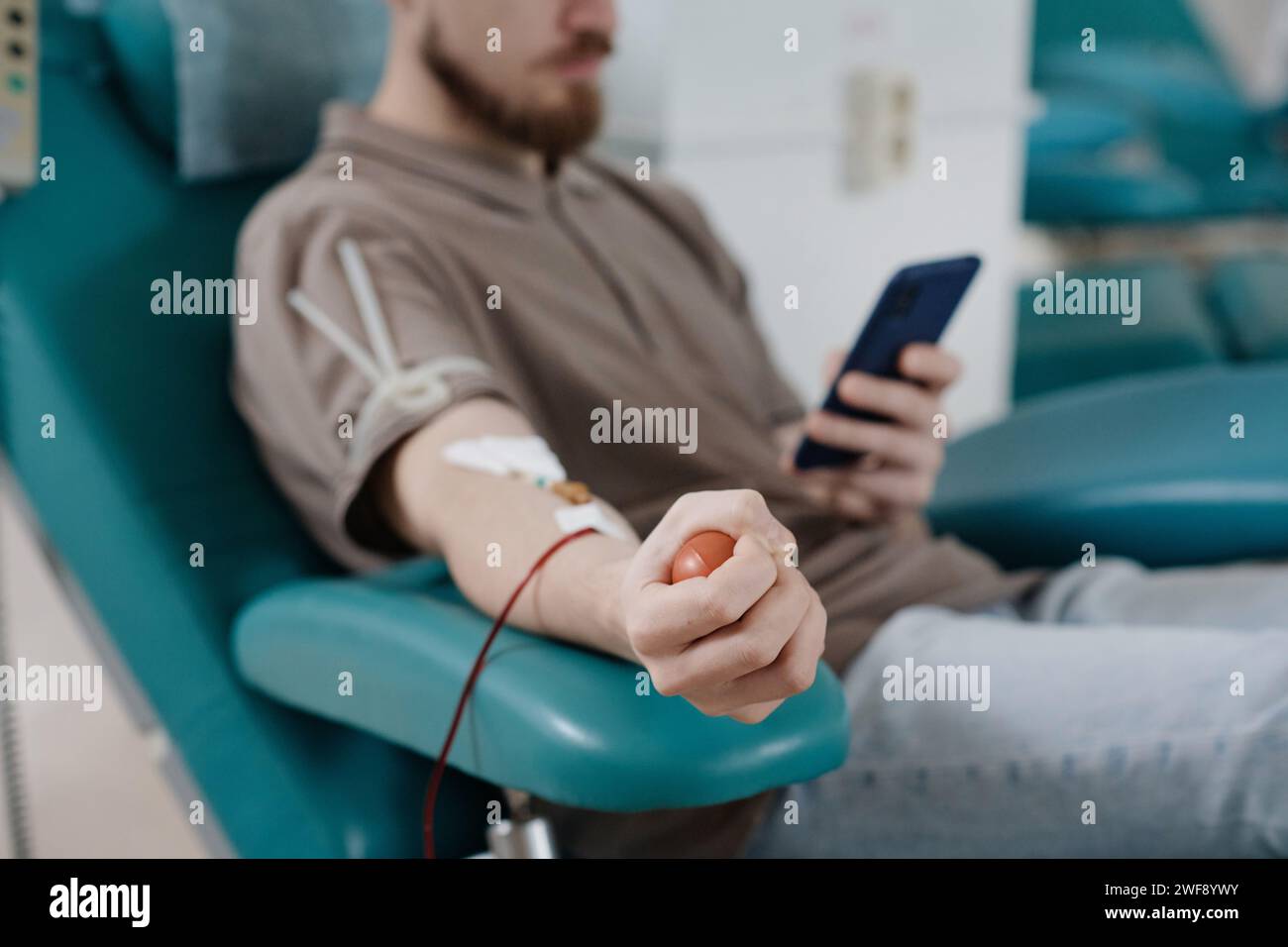 Unrecognizable caucasian man squeezing red rubber ball during blood ...