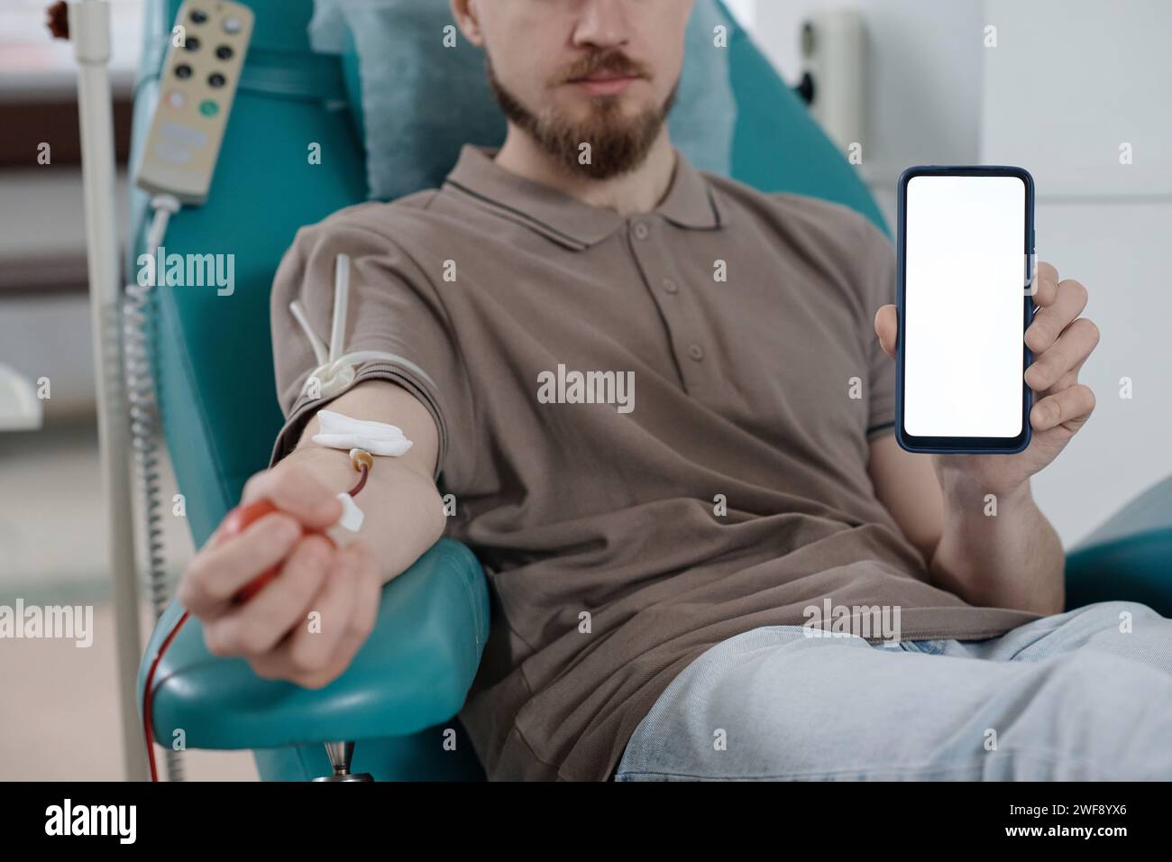 Male donor showing blank screen of his smartphone to camera during ...